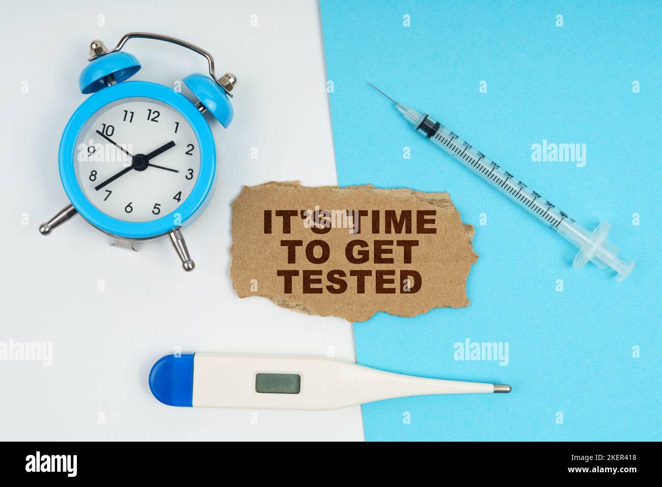 Medical concept. A clock, a thermometer, a syringe and a cardboard with ...