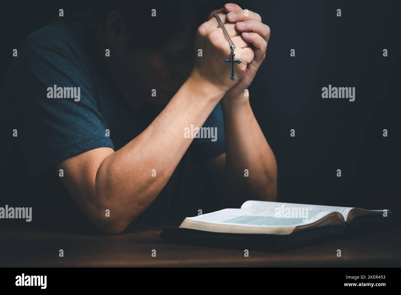 Man reading holy bible book and folding hands pray to God Stock Photo ...