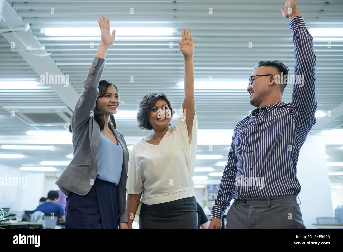 Happy excited Asian business people rising hands Stock Photo - Alamy