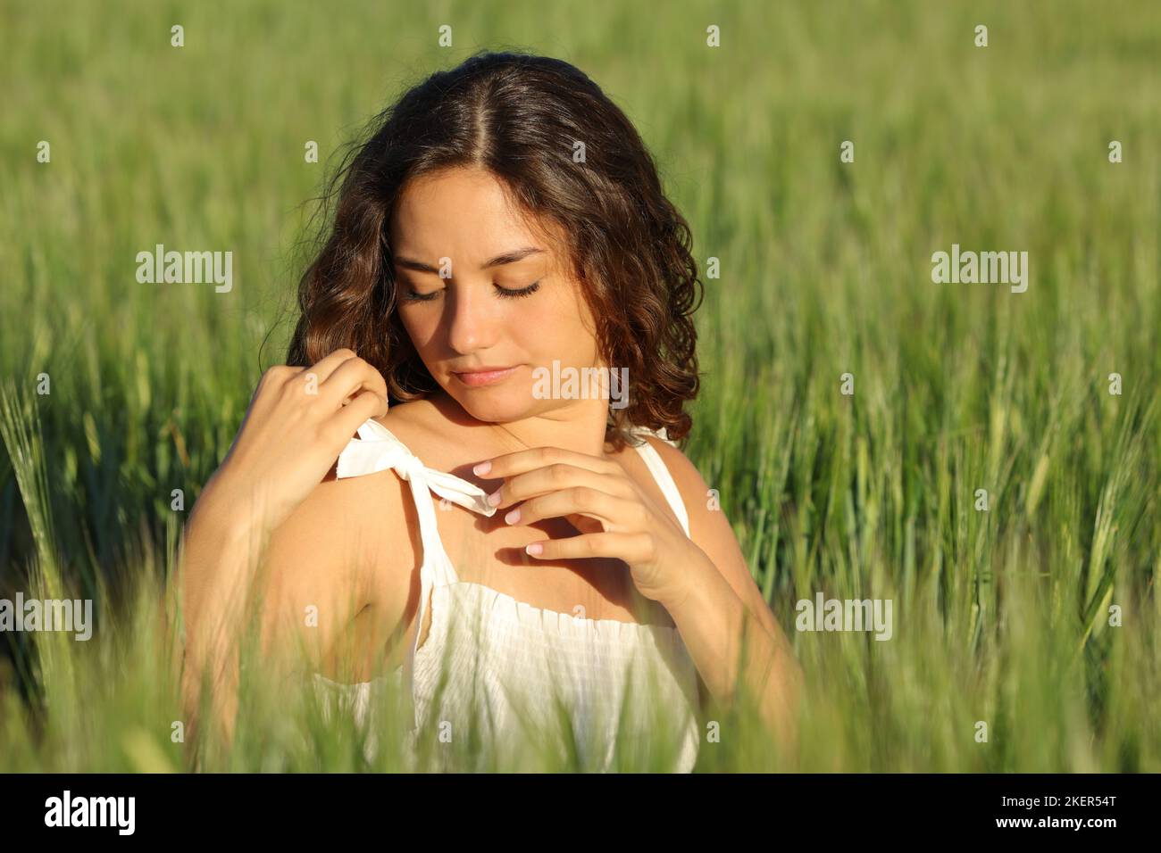 Woman tying dress lace in the mittle of a wheat field Stock Photo - Alamy
