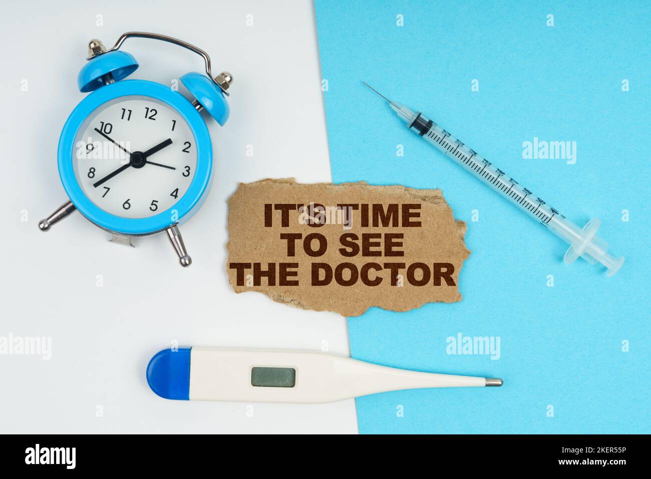 Medical concept. A clock, a thermometer, a syringe and a cardboard with ...