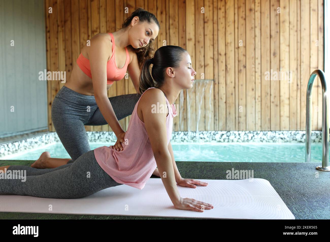 Yoga teacher teaching a student the right pose in spa Stock Photo - Alamy