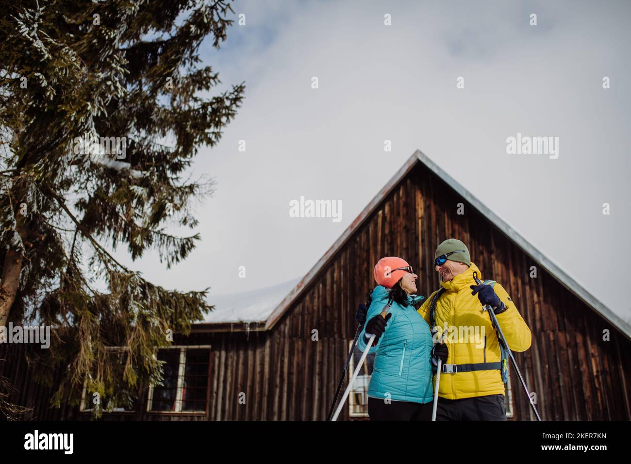 Senior couple having break during skying, next forest cottage Stock ...