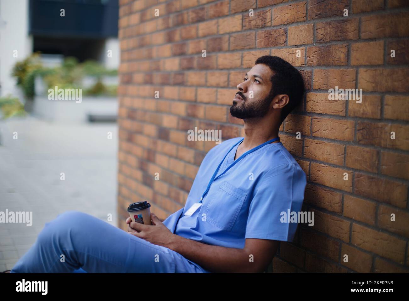 Tired caregiver man resting outdoor, in front of nurishing home Stock ...