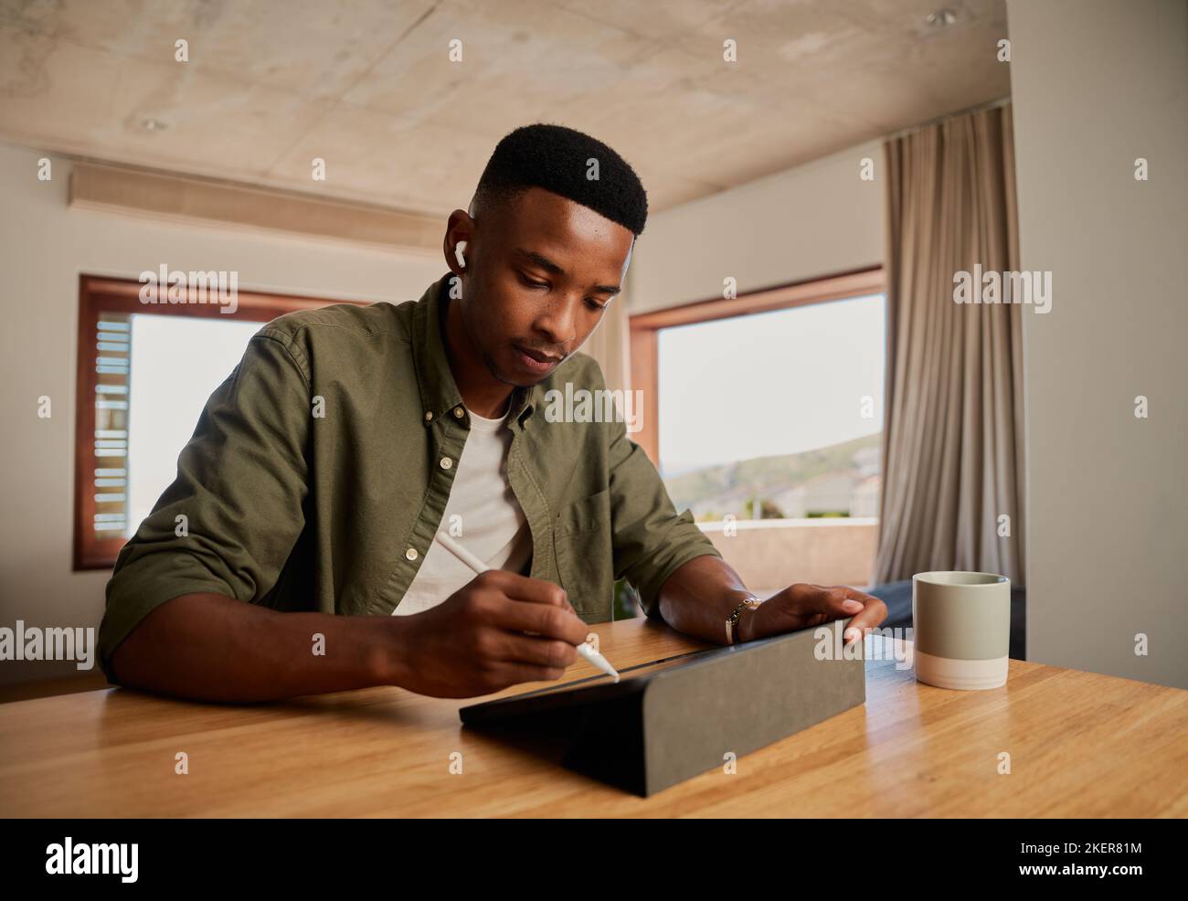 Focussed young adult black African American male writing with pen on ...