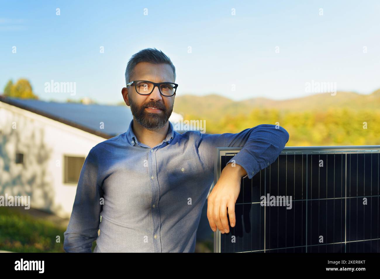 Happy owner holding solar panel, standing in front of his house Stock ...