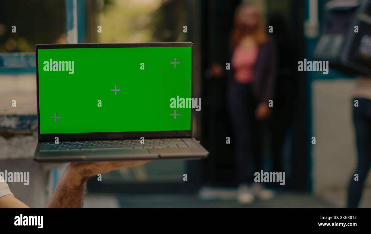 Man holding laptop with greenscreen on display, delivering food order ...