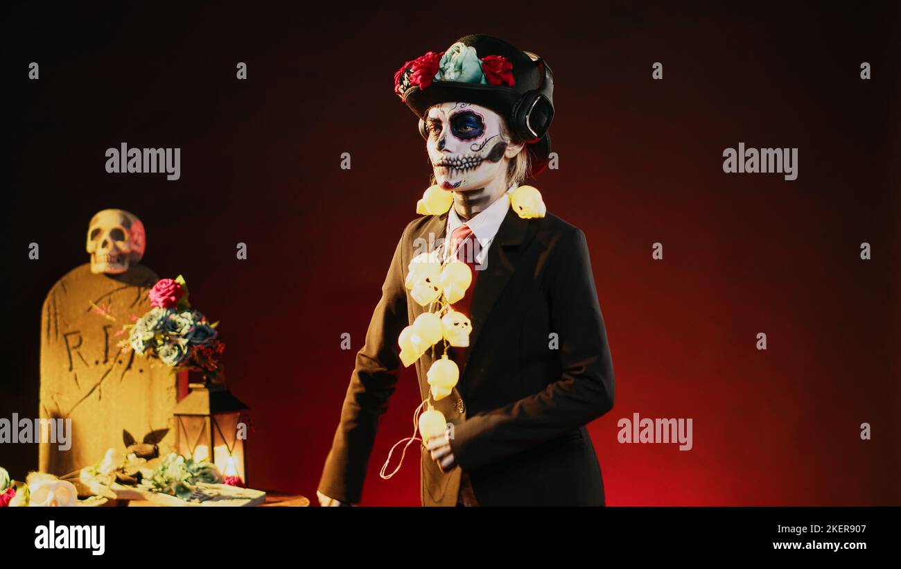 Scary woman with costume of death dancing in studio, listening to music ...