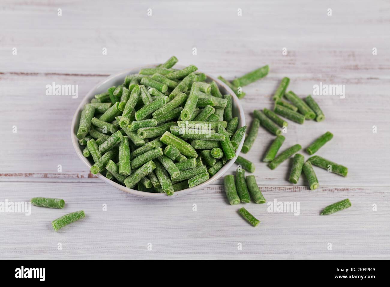 Composition with organic frozen vegetables on a white wooden background ...