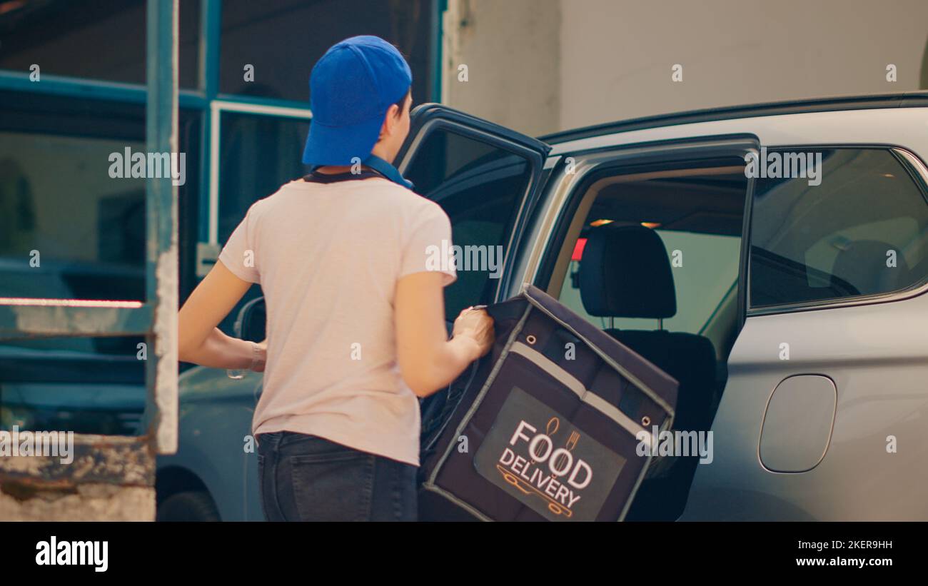 Woman delivery service worker leaving car to deliver food package at ...
