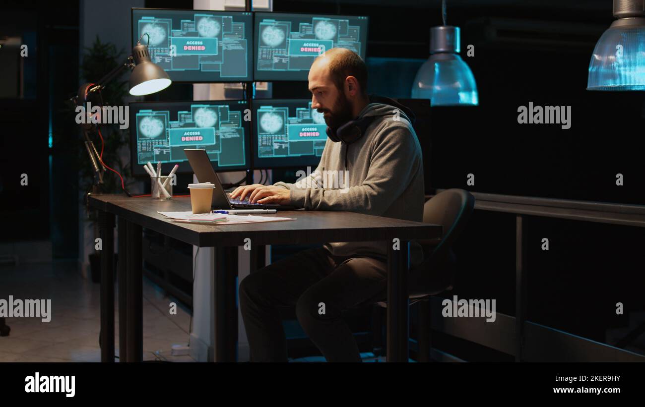 Aggressive angry criminal trying to hack network at night, feeling mad ...