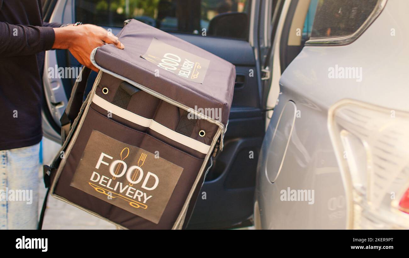 African american carrier getting out of car to deliver food package ...