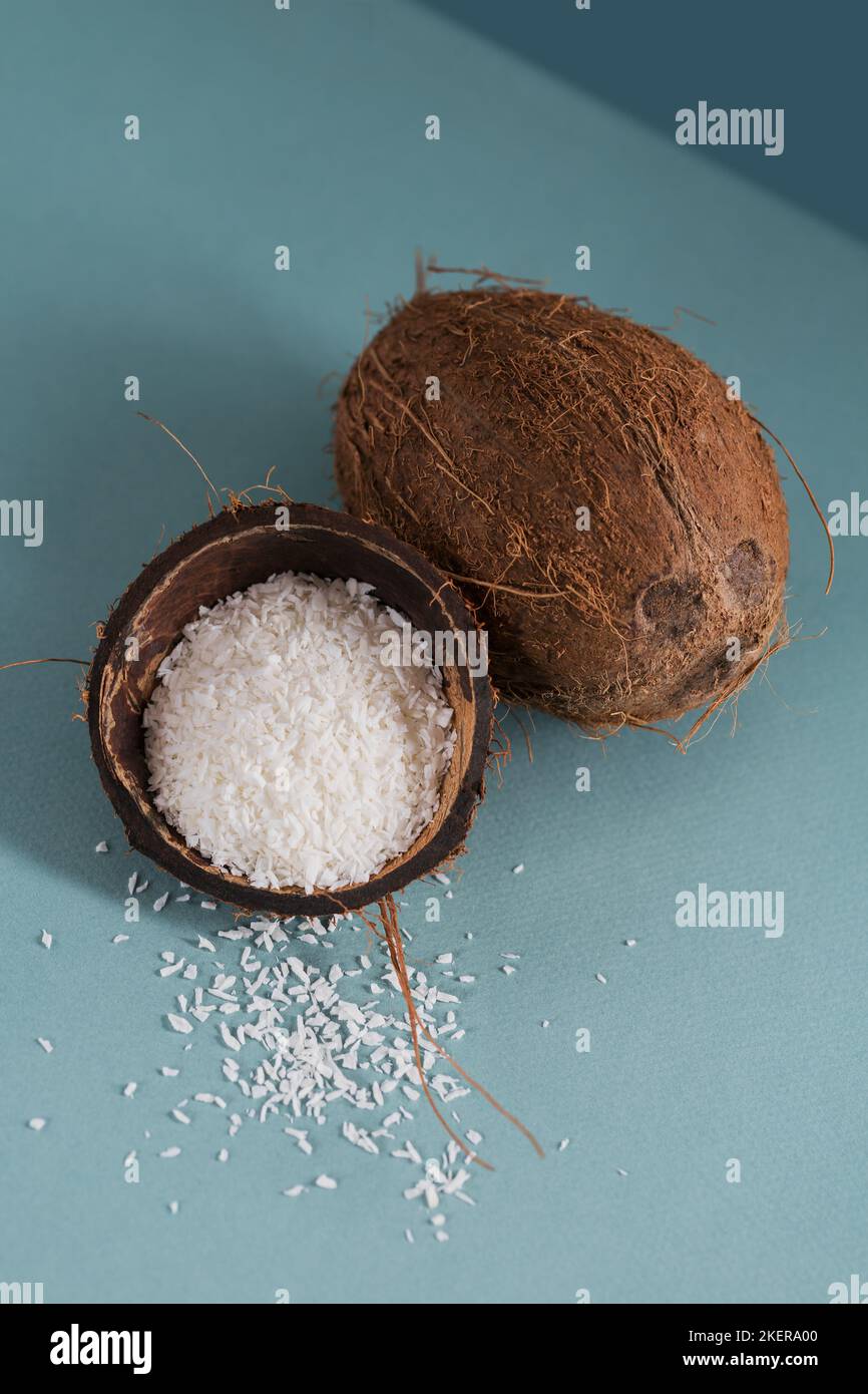 Whole coconut with coconuts flakes on a blue background Stock Photo - Alamy