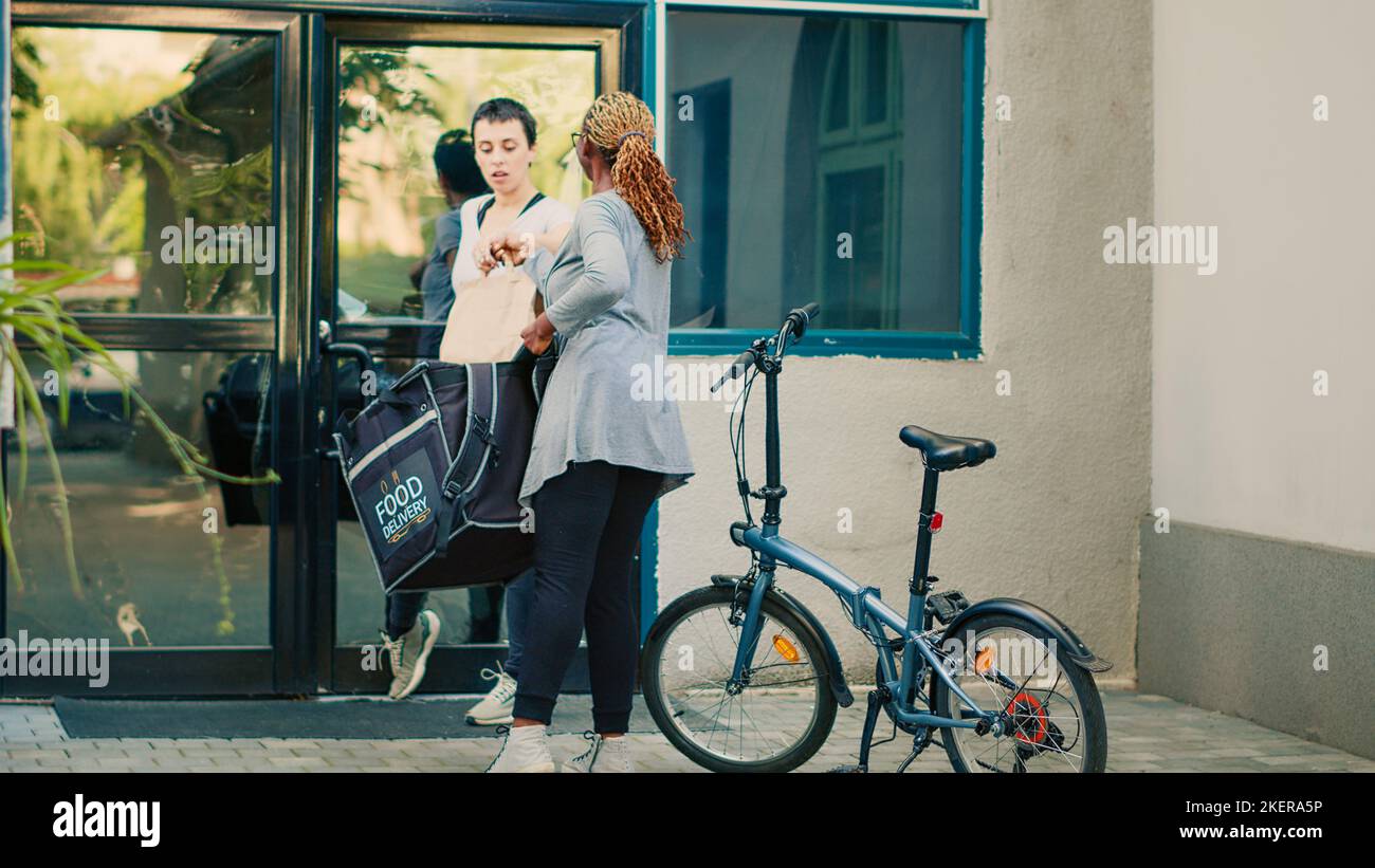 Food delivery worker carrying backpack to deliver fastfood order ...
