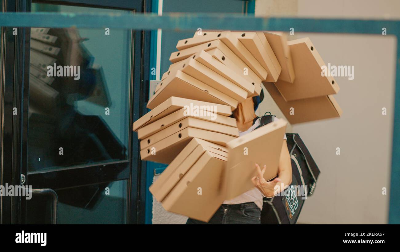 Fastfood meal courier dropping pizza boxes pile outside building ...