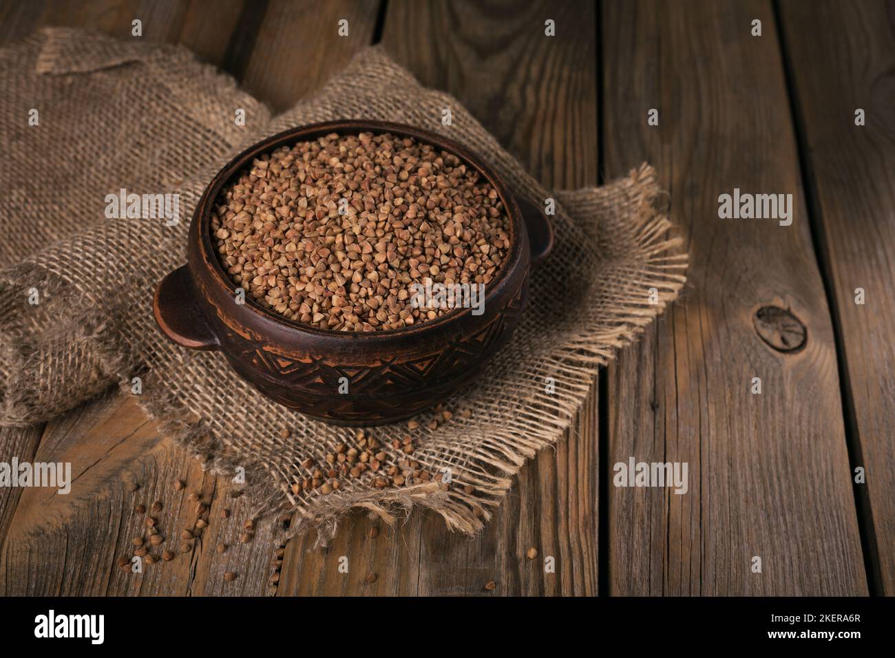 Bowl of dry raw buckwheat groats on a wooden background. Cooking ...