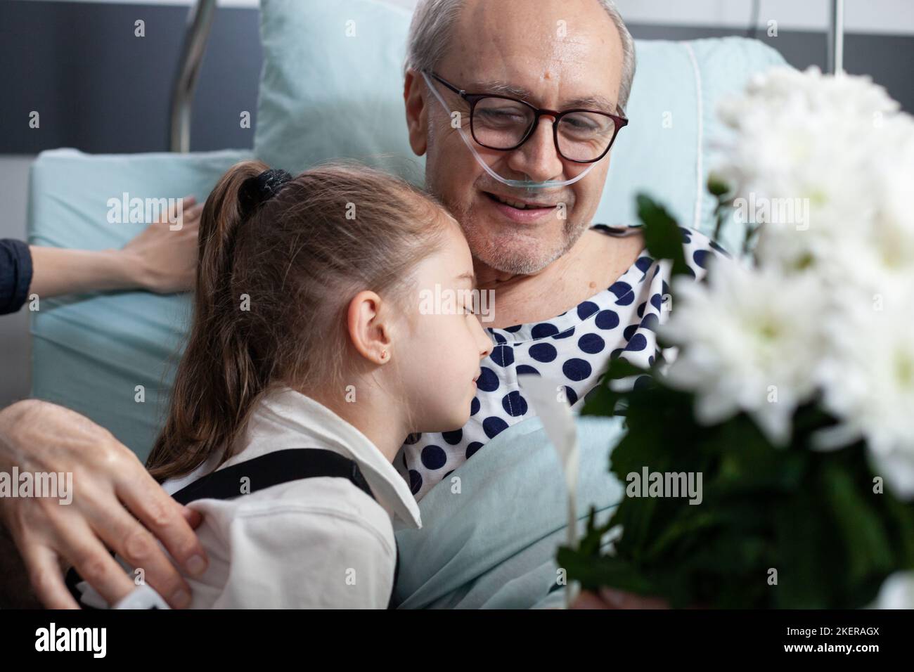Girl hugging old man, lying in hospital bed. Senior, granddaughter ...