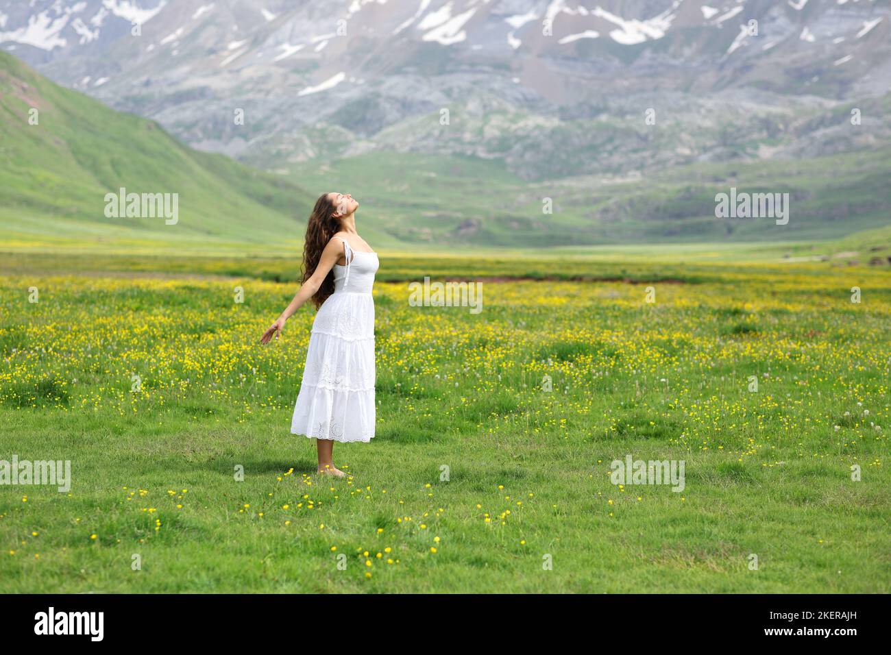 Side view portrait of a woman with white dress breathing fresh air in ...