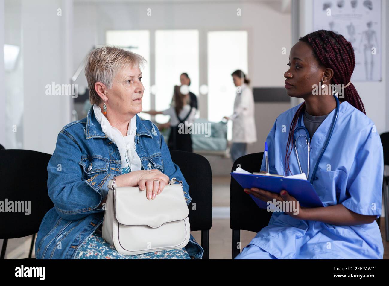 African american nurse filling out elderly woman admission paperwork ...