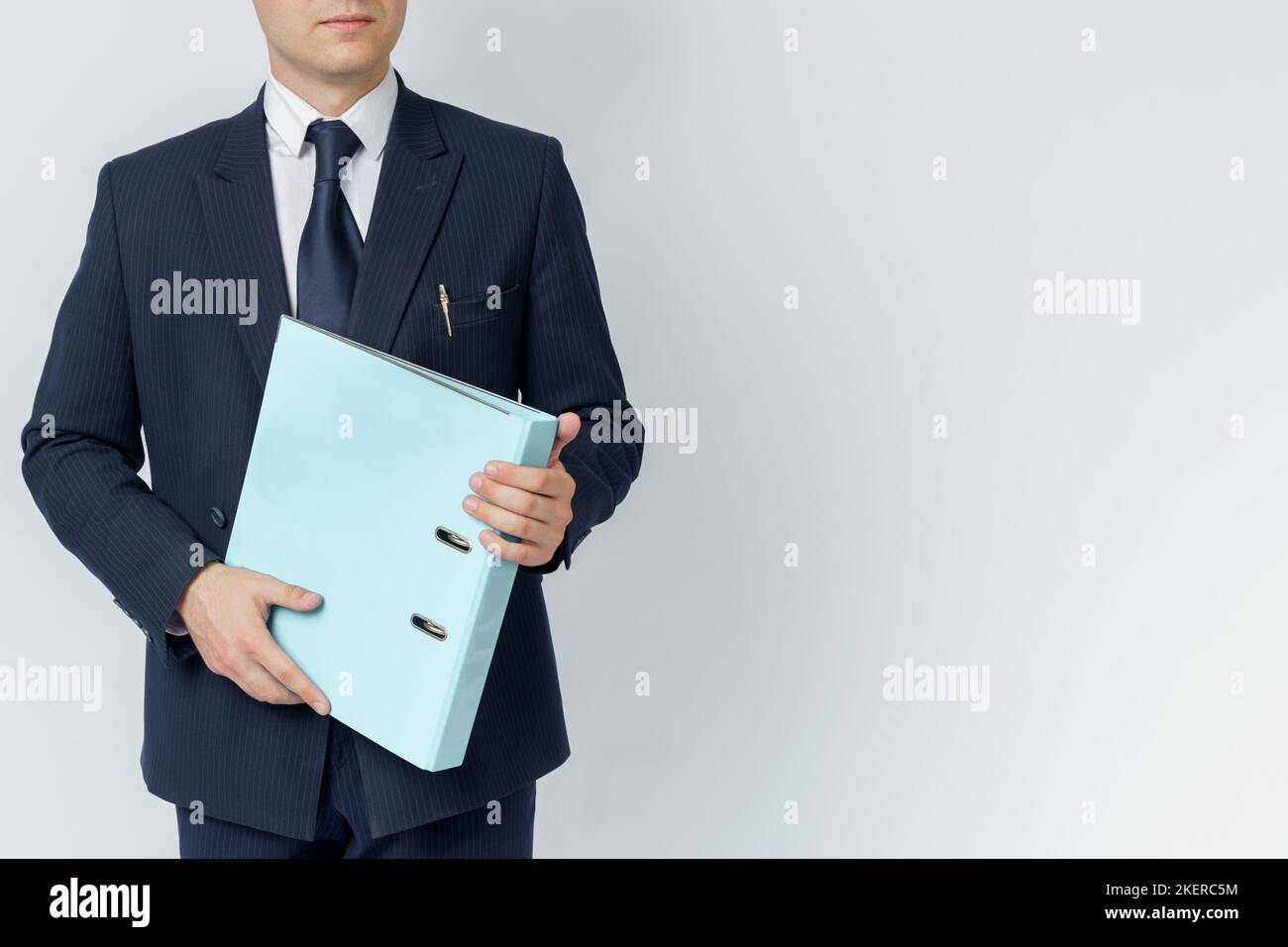 Businessman in a blue suit holds a folder in his hands on a white ...