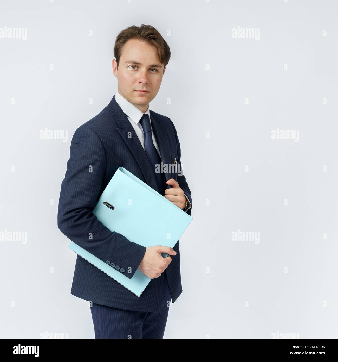 A businessman in a blue suit holds folders on a white background ...