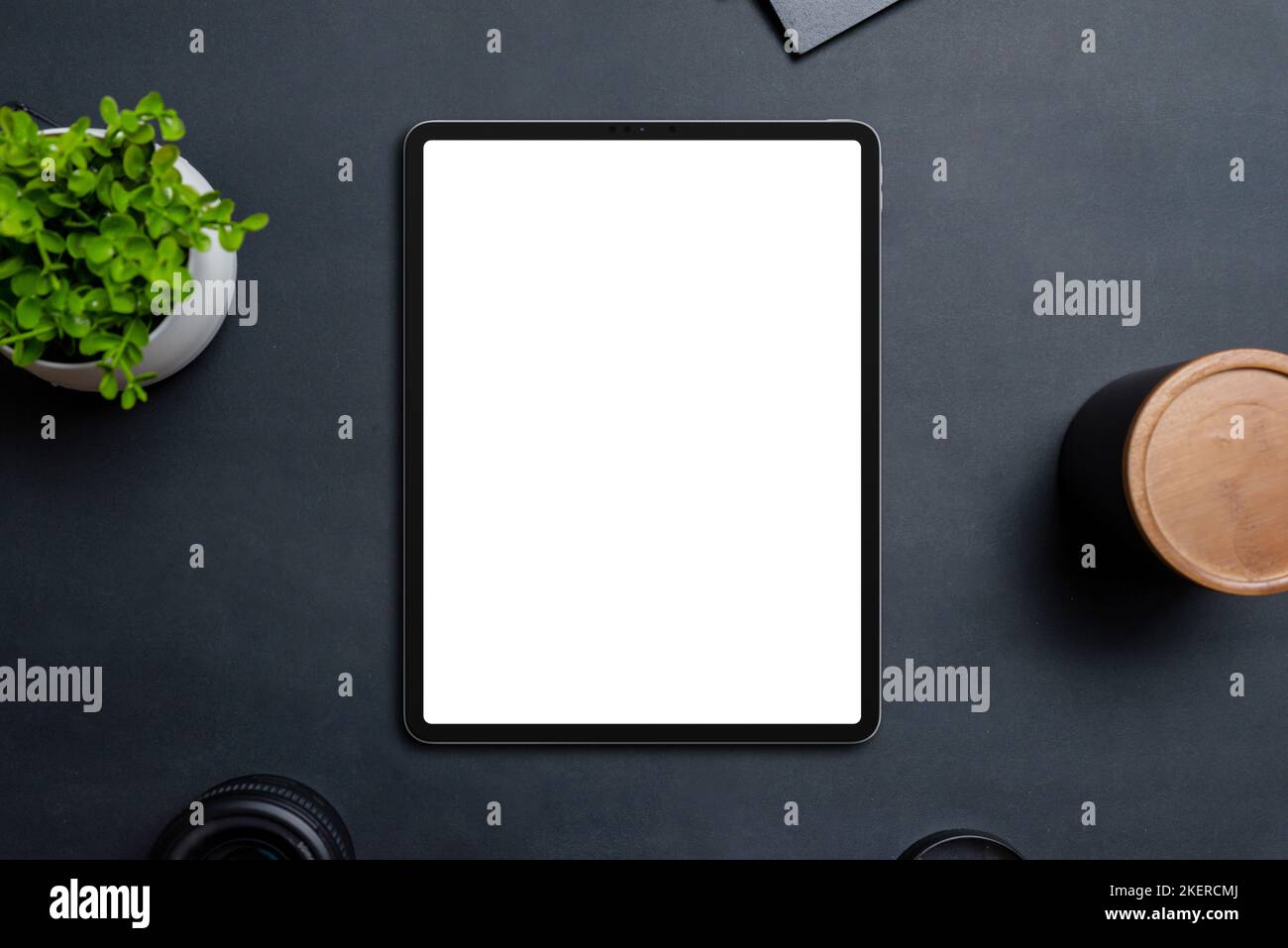 Tablet mockup on black table surrounded by objects. Isolated display in ...