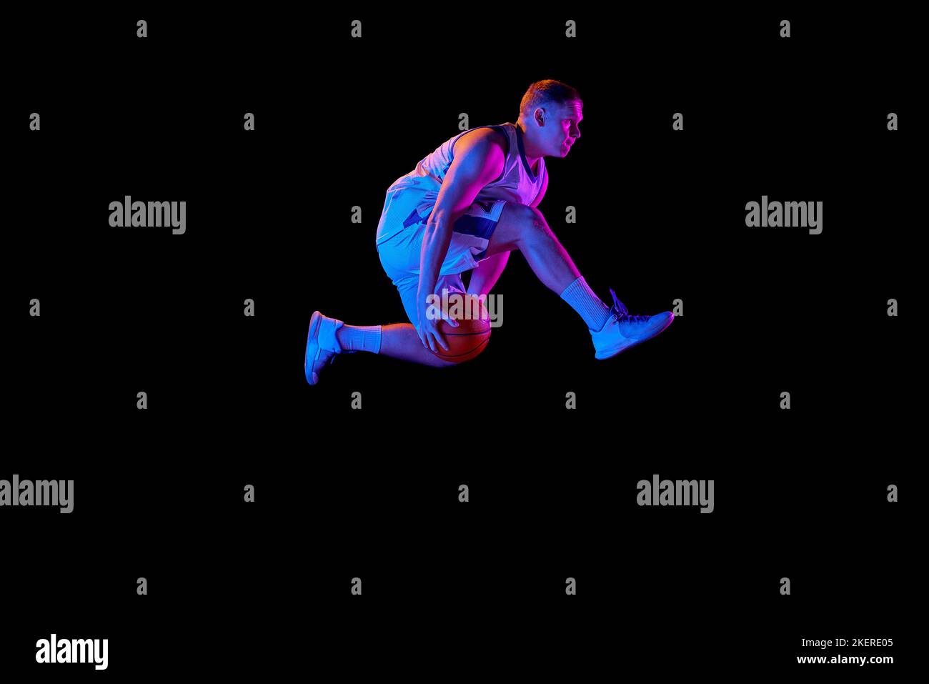 Active athletic male basketball player jumping with basketball ball ...
