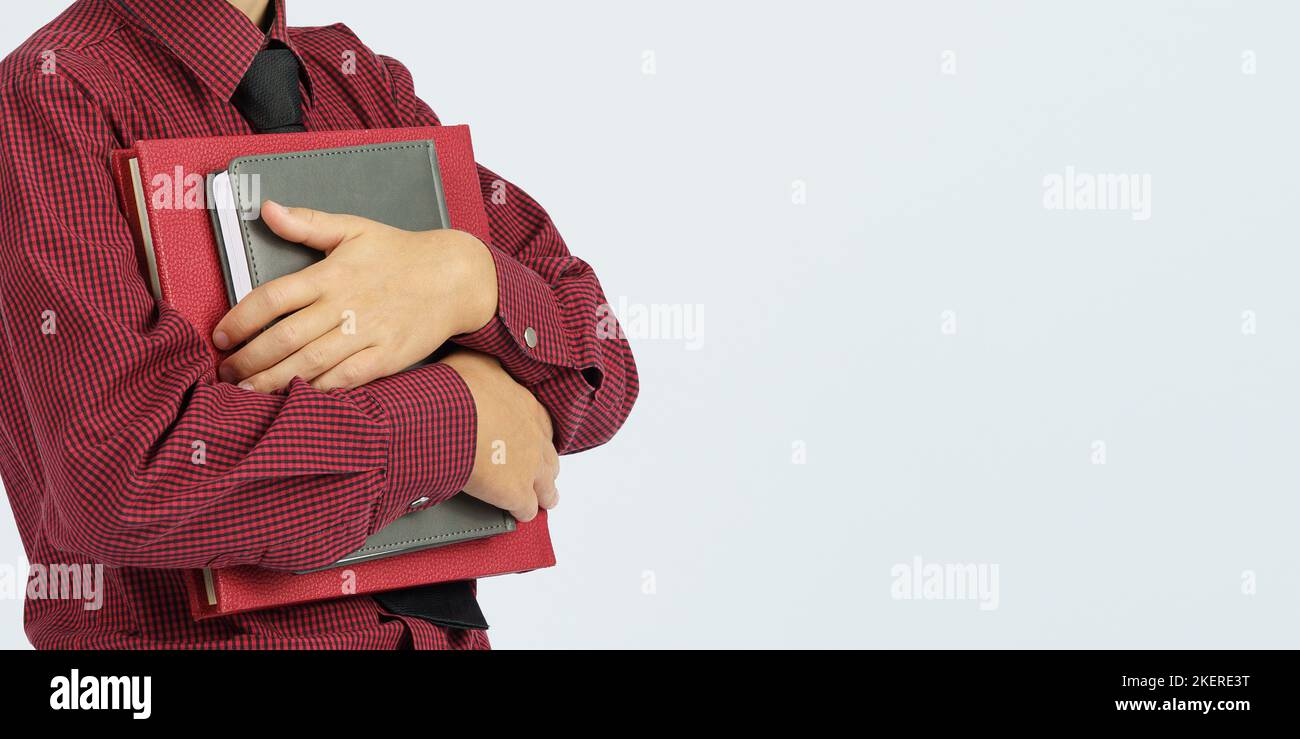 Pupil holding books in hands, isolated background. Education concept ...