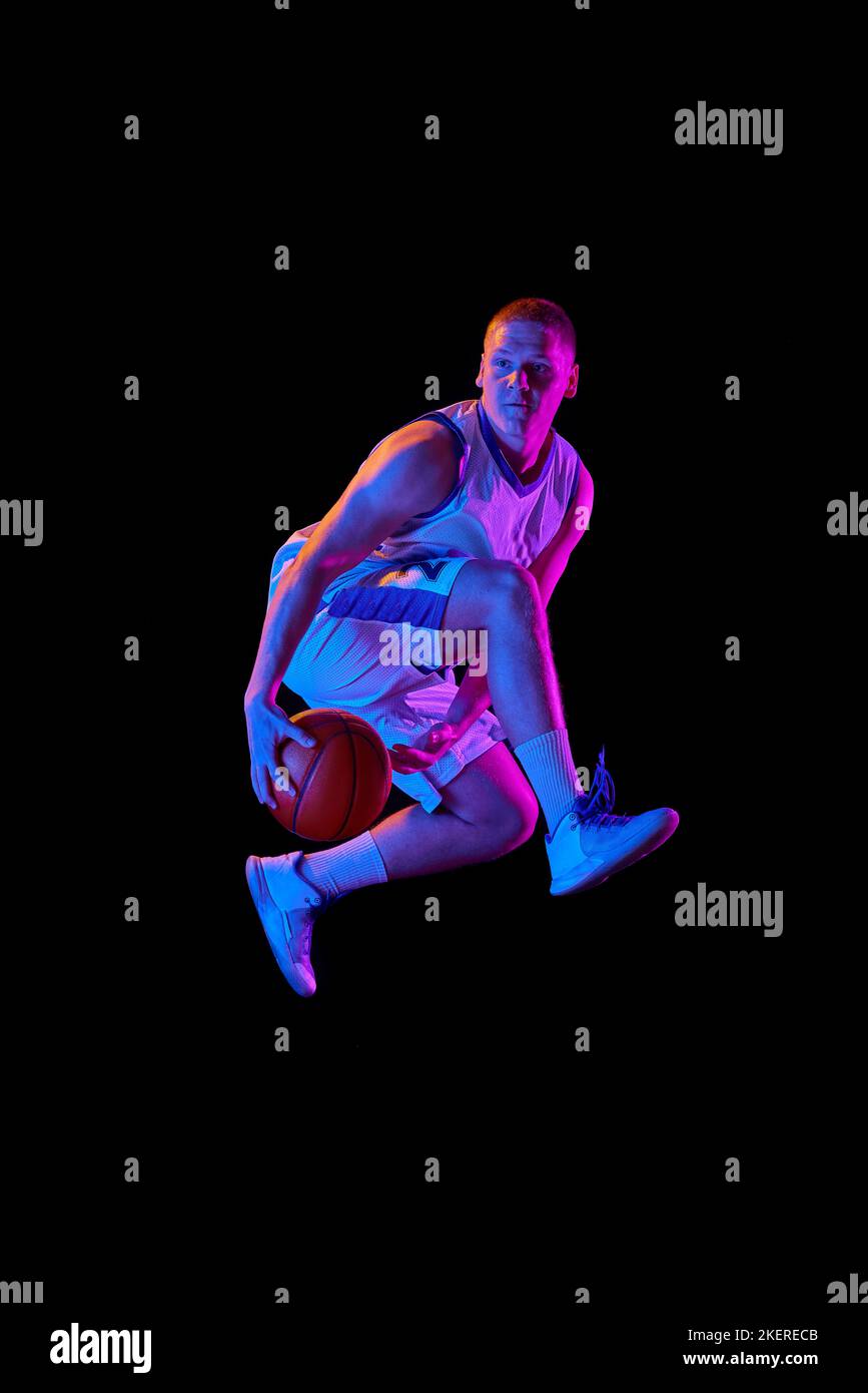 Active athletic male basketball player jumping with basketball ball ...