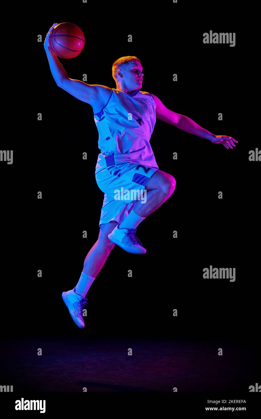 Active athletic male basketball player jumping with basketball ball ...