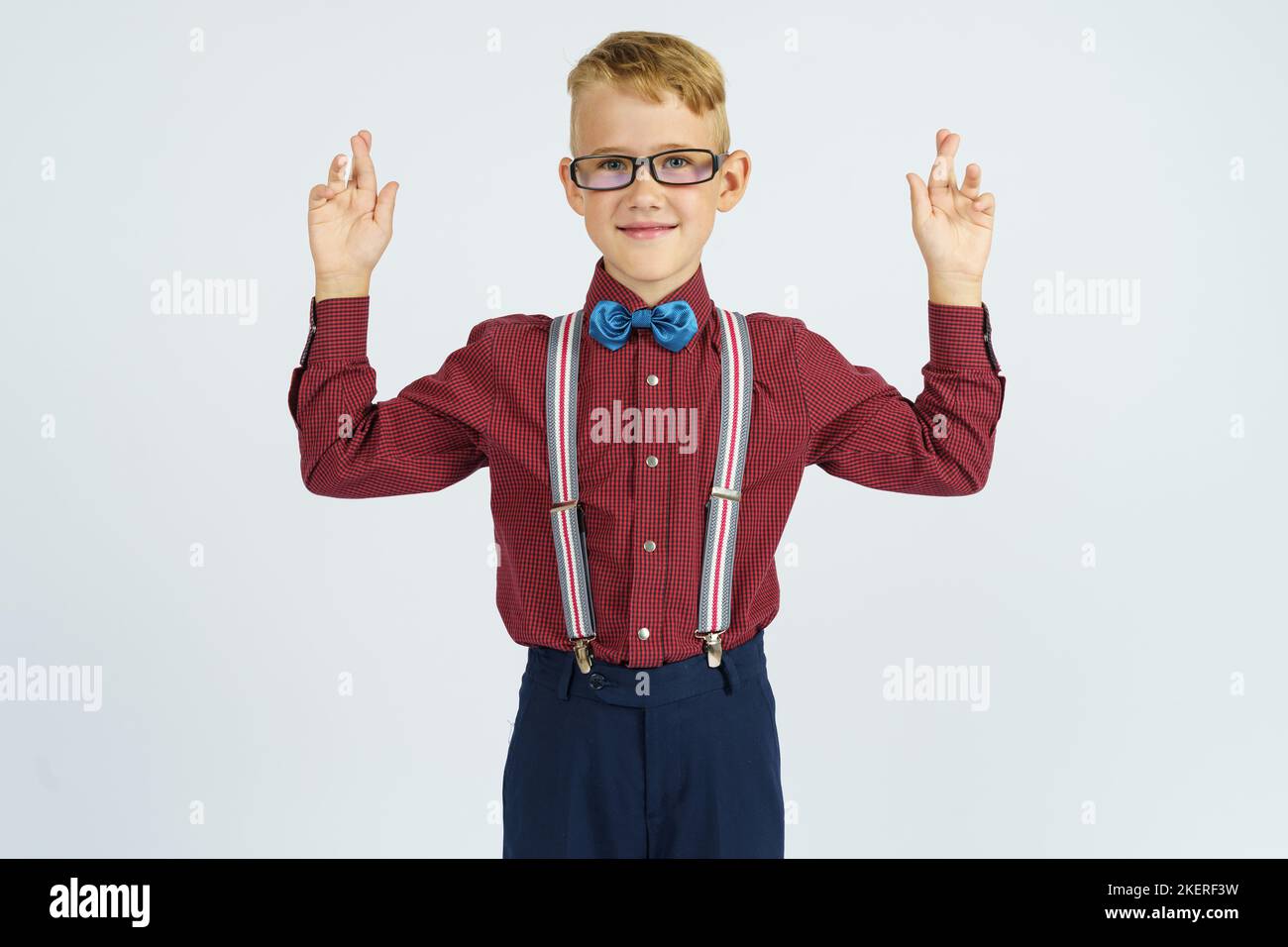 A portrait of a schoolboy who raised his hands up - fingers are twisted ...