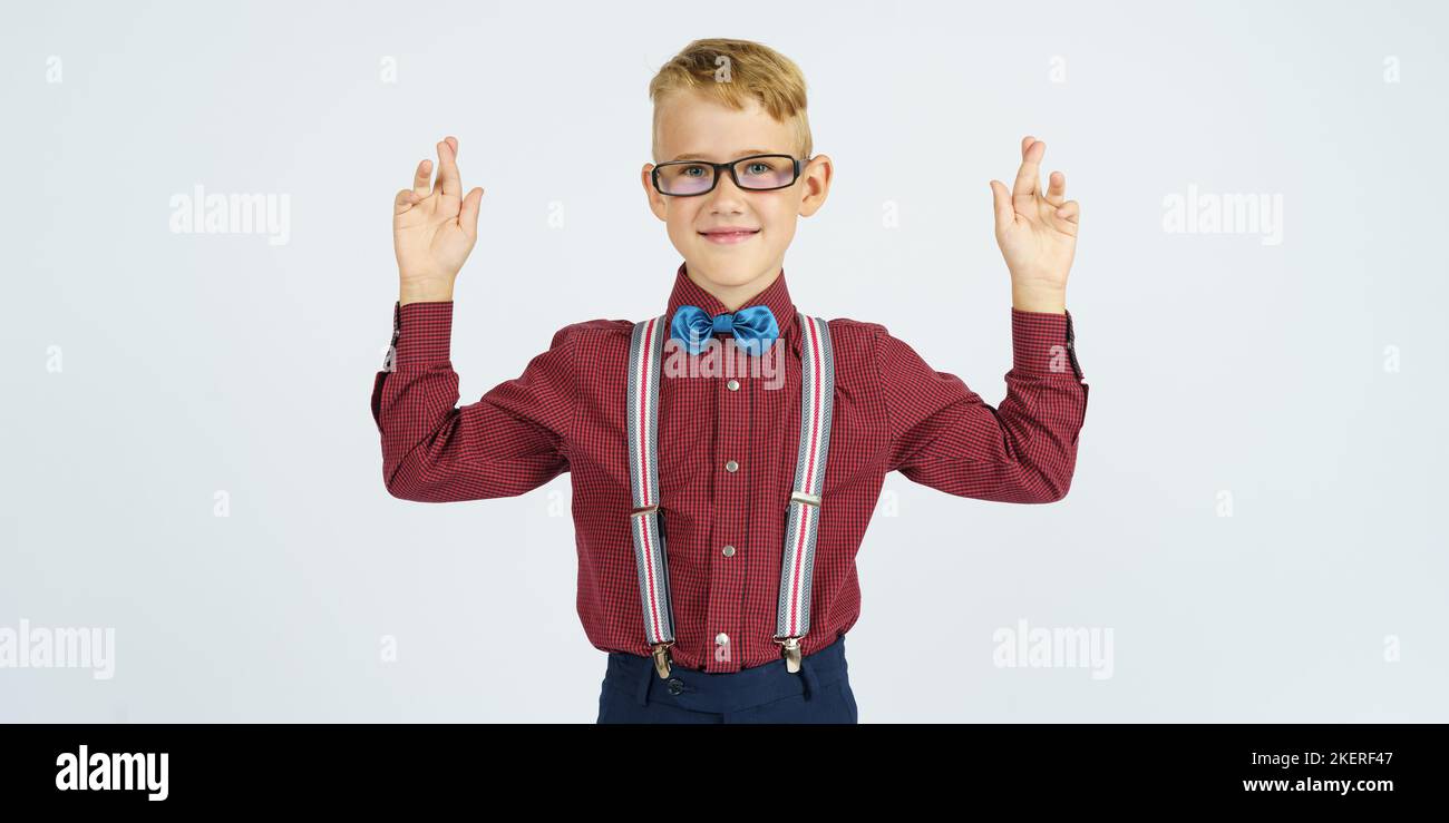 A portrait of a schoolboy who raised his hands up - fingers are twisted ...