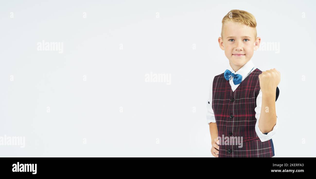 A portrait of a schoolboy who clenches his hands into a fist ...