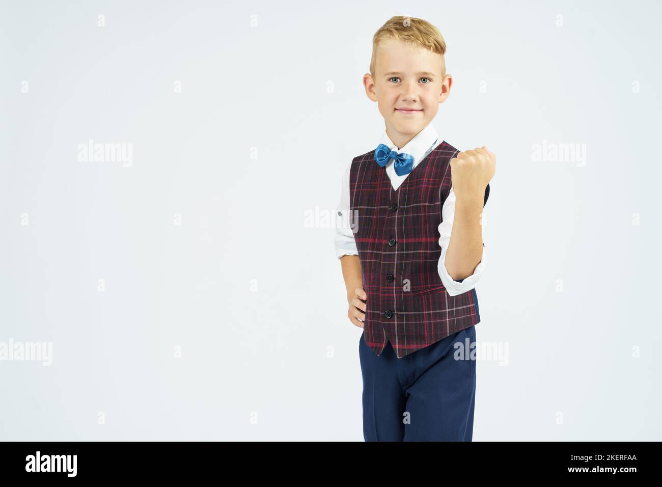 A portrait of a schoolboy who clenches his hands into a fist ...