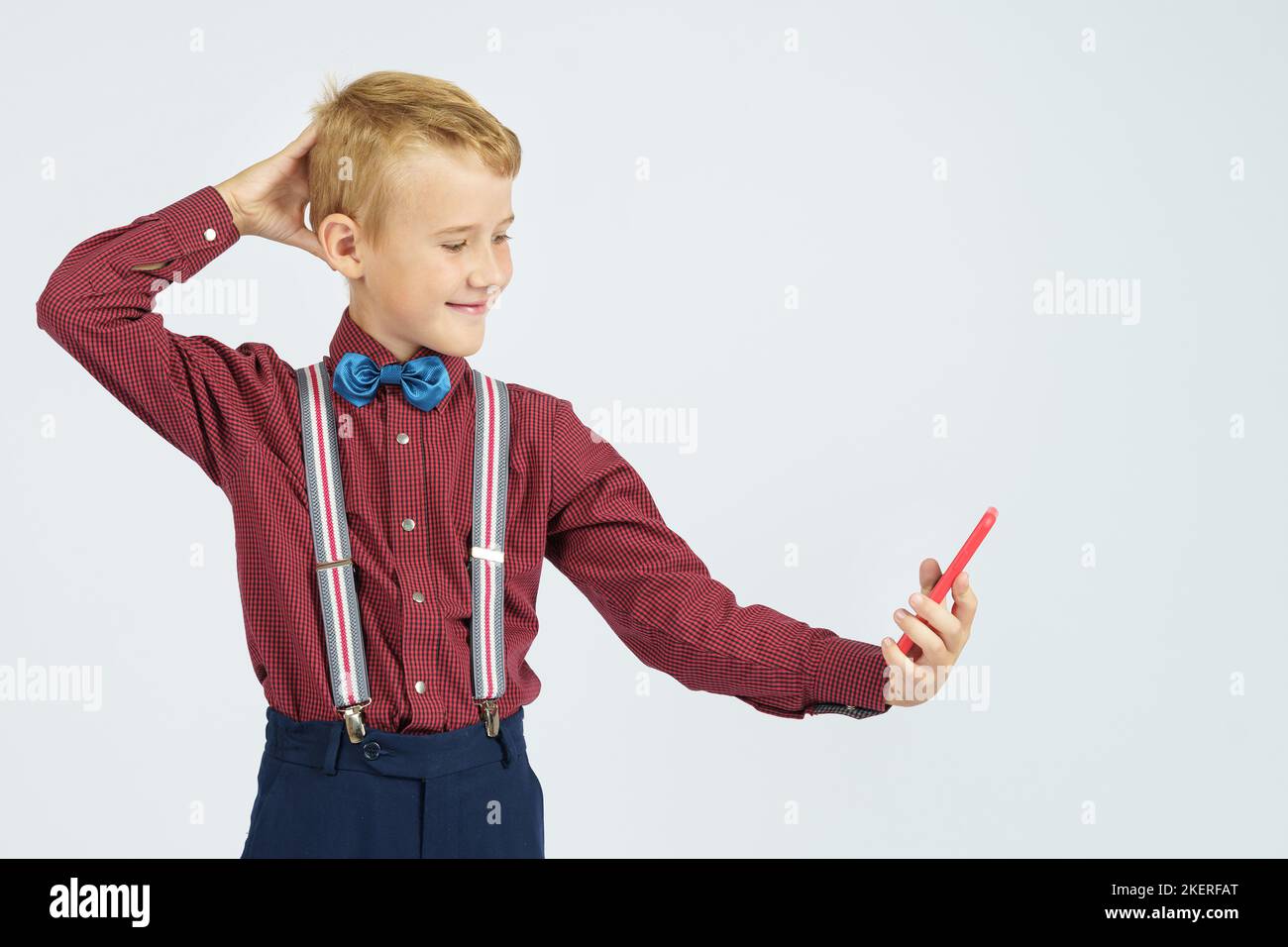 Portrait of a schoolboy taking a selfie on a mobile phone. Isolated ...