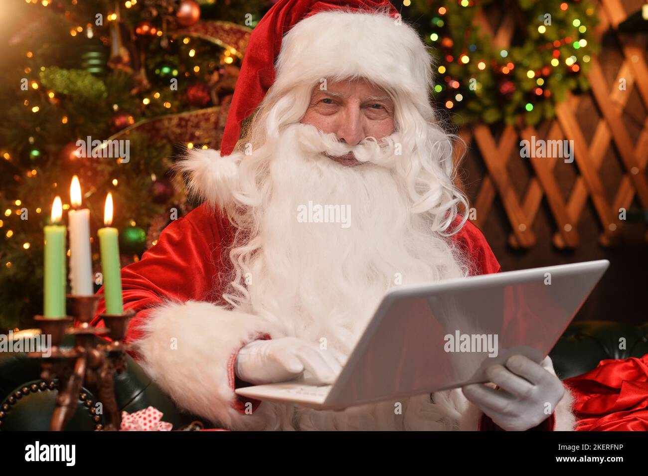 Santa Claus in a traditional costume sits with a laptop Stock Photo - Alamy