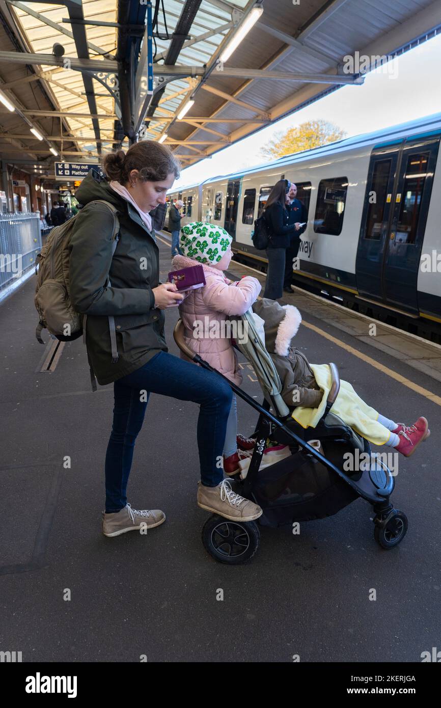 A mother texting on her smartphone with her two young children and a ...