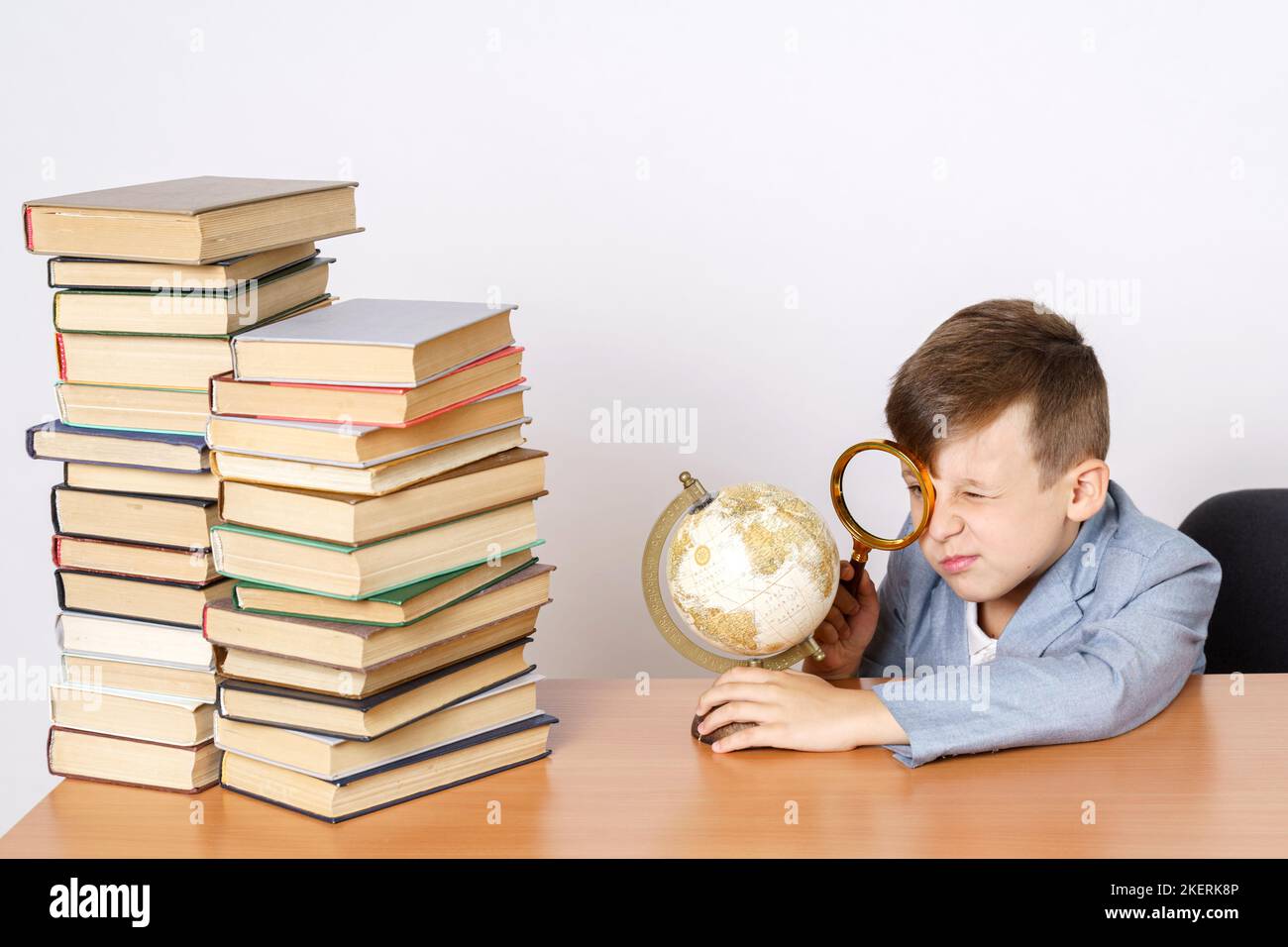 Education concept. The student does homework, studies the globe. He has ...