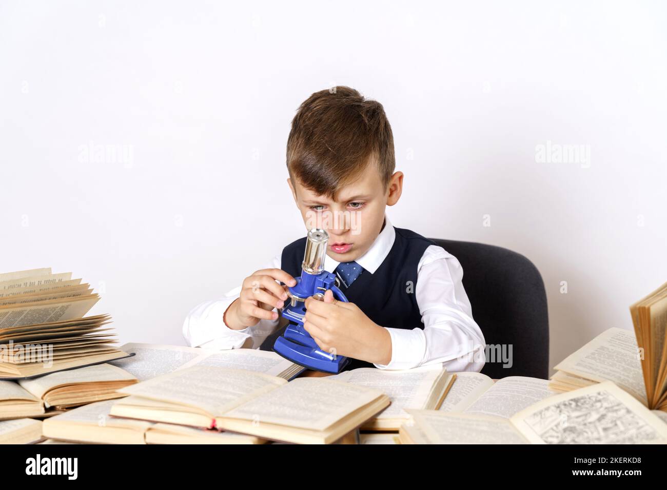 Education concept. The student does homework, studies the microscope ...