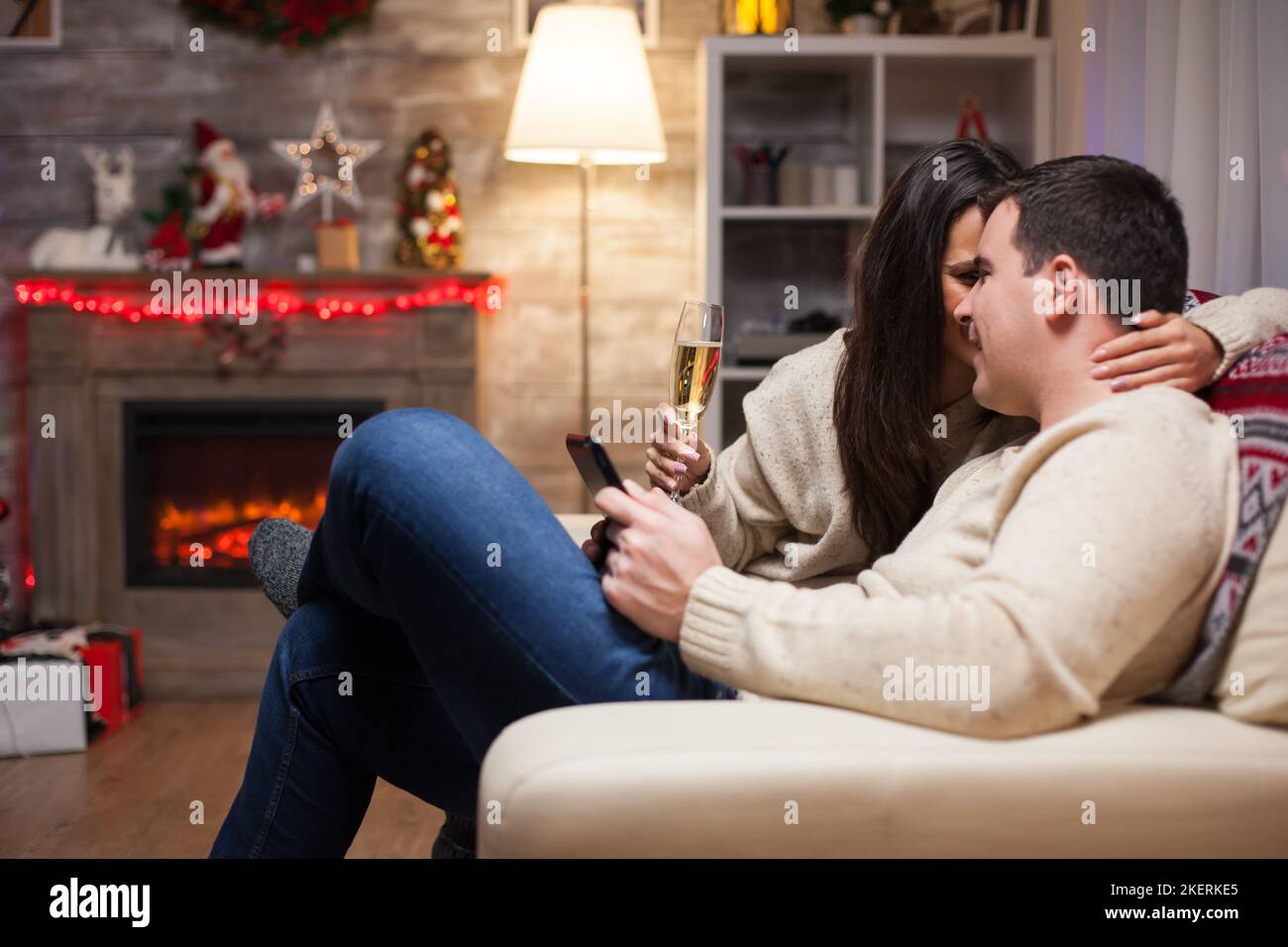 Beautiful woman holding a glass of wine and whispering something to her ...