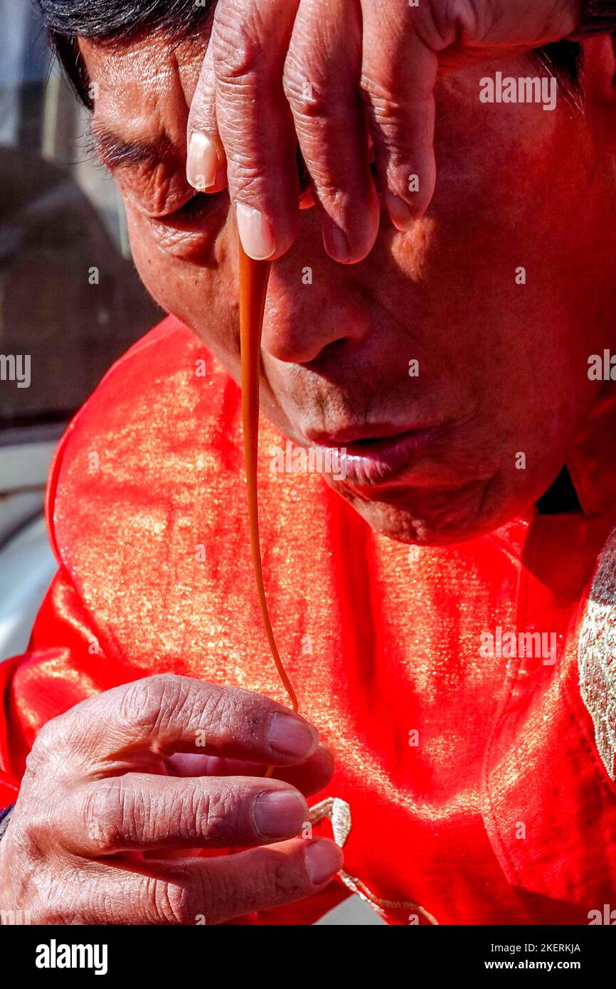 Folk artist Ma Diankun is performing the Sugar Figure Blowing Art which is an intangible ...