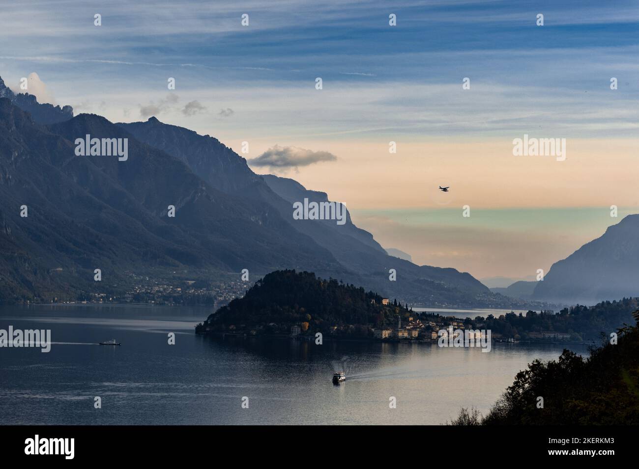 A breathtaking view of Lake Como with a passing jet and sailing boats ...