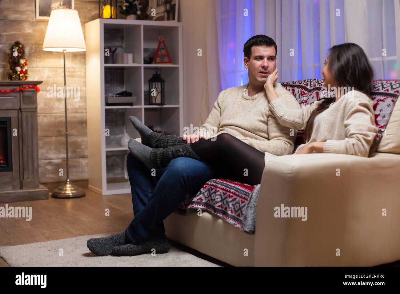 Husband looking deeply into her wife eyes sitting on couch celebrating ...
