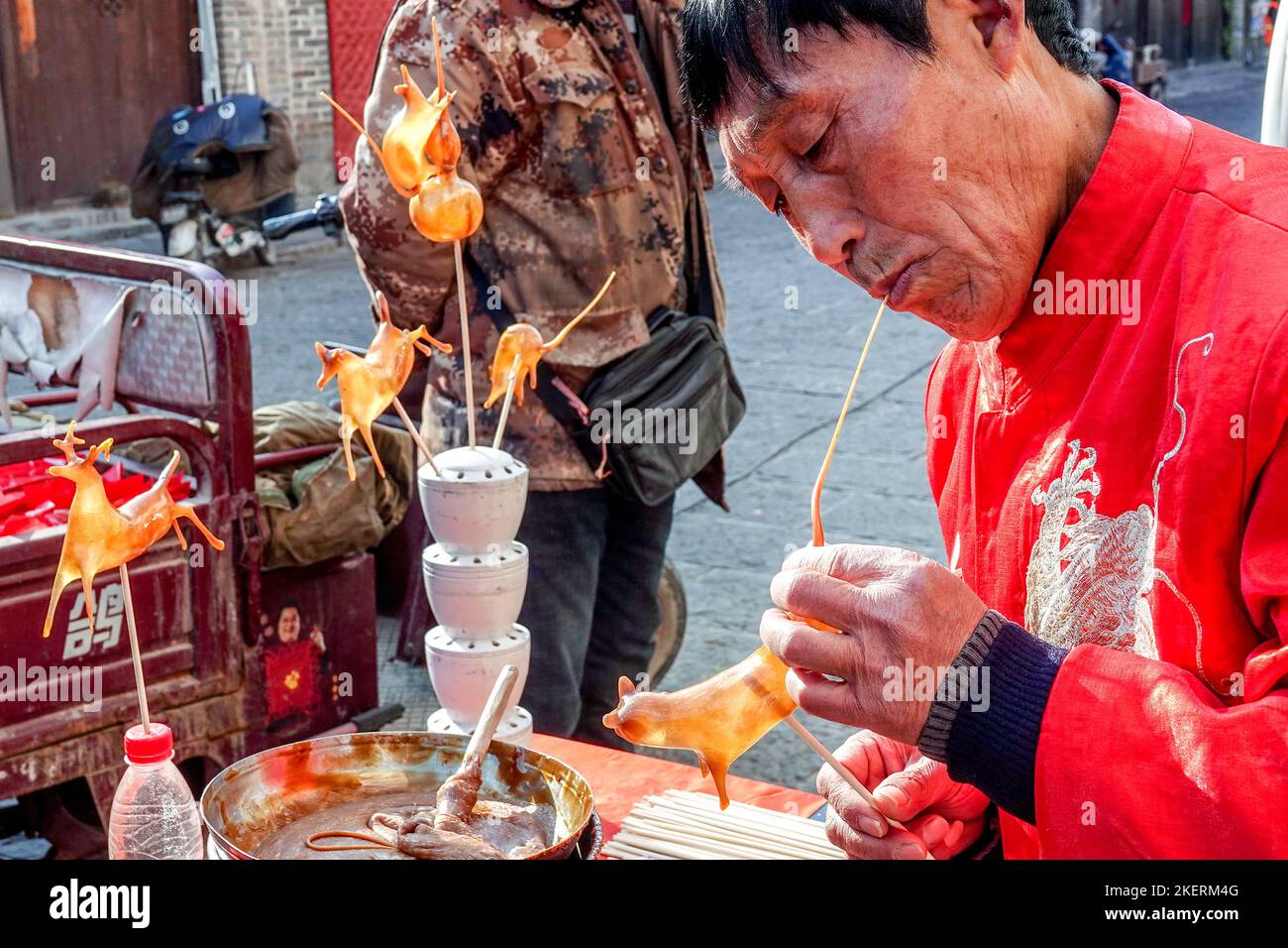 Folk artist Ma Diankun is performing the Sugar Figure Blowing Art which is an intangible ...