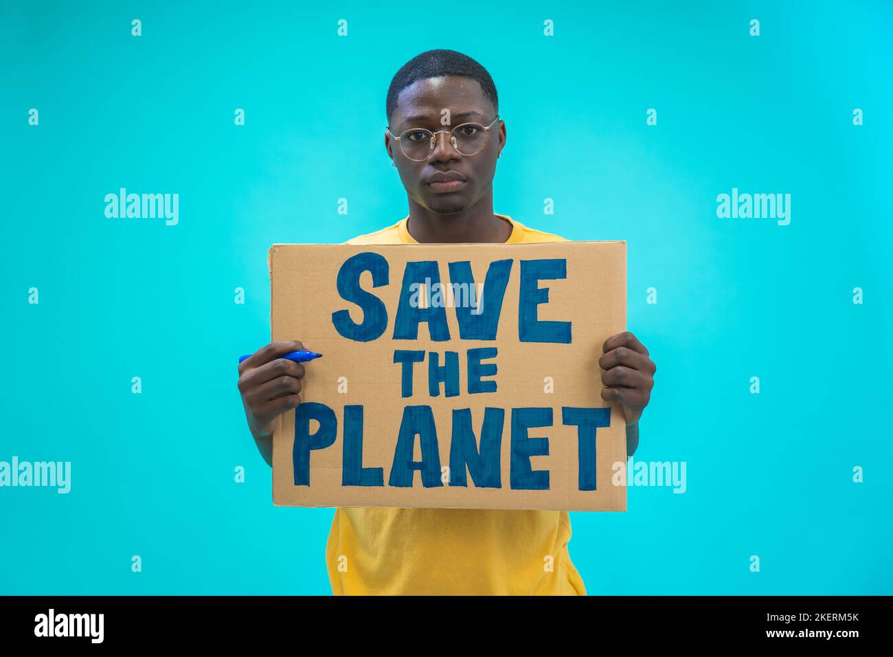 Young black man holding save the planet sign protesting climate change ...