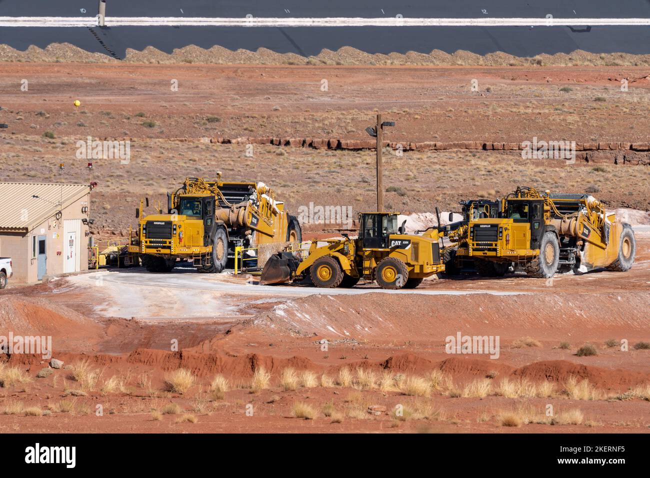 A heavy-duty scraper dumping a load of potash into a slurry pit for ...