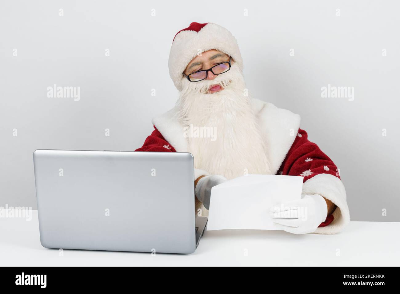Christmas and New Year concept. Santa Claus is sitting at his desk and ...