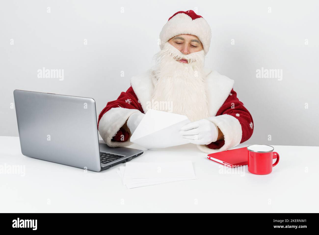 Christmas and New Year concept. Santa Claus is sitting at his desk and ...