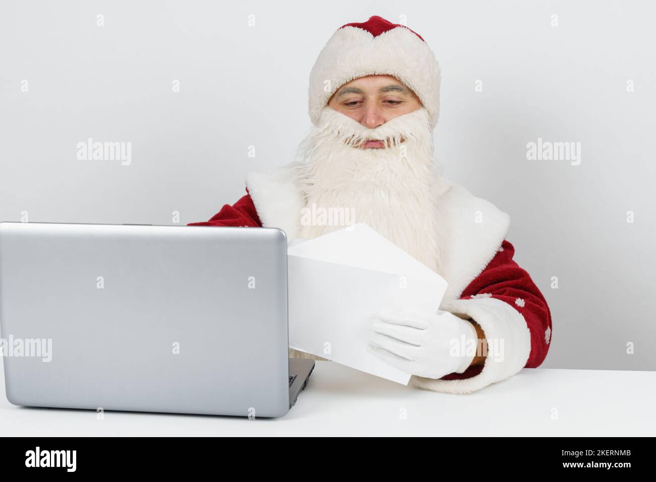 Christmas and New Year concept. Santa Claus is sitting at his desk and ...