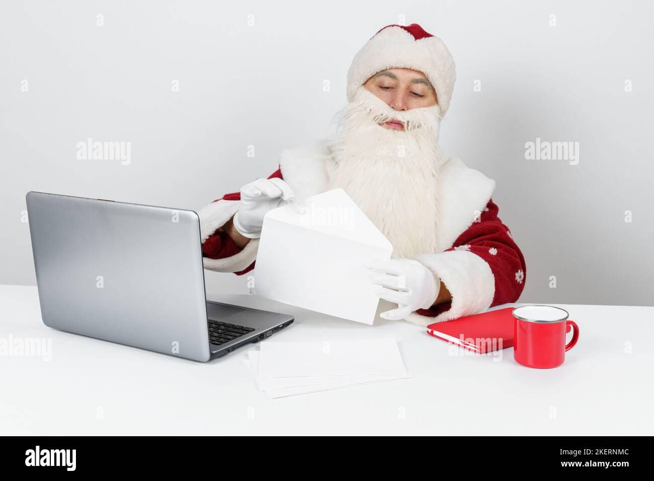Christmas and New Year concept. Santa Claus is sitting at his desk and ...